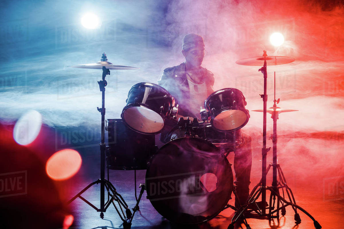 Male musician in leather jacket playing drums during rock concert on ...