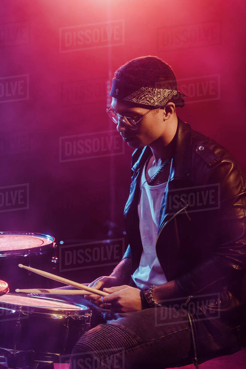 Male musician in leather jacket playing drums during rock concert on ...