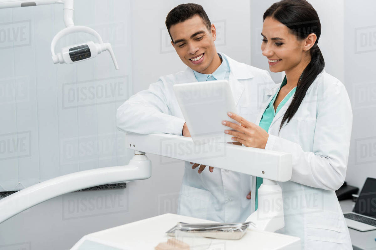 Cheerful multicultural doctors looking at digital tablet - Stock Photo ...