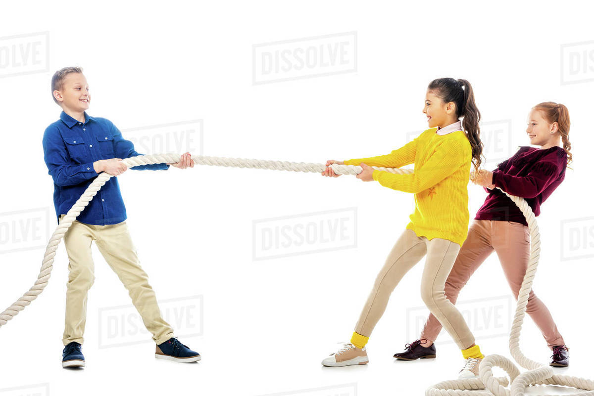Cheerful boy and two schoolgirls pulling rope isolated on white ...