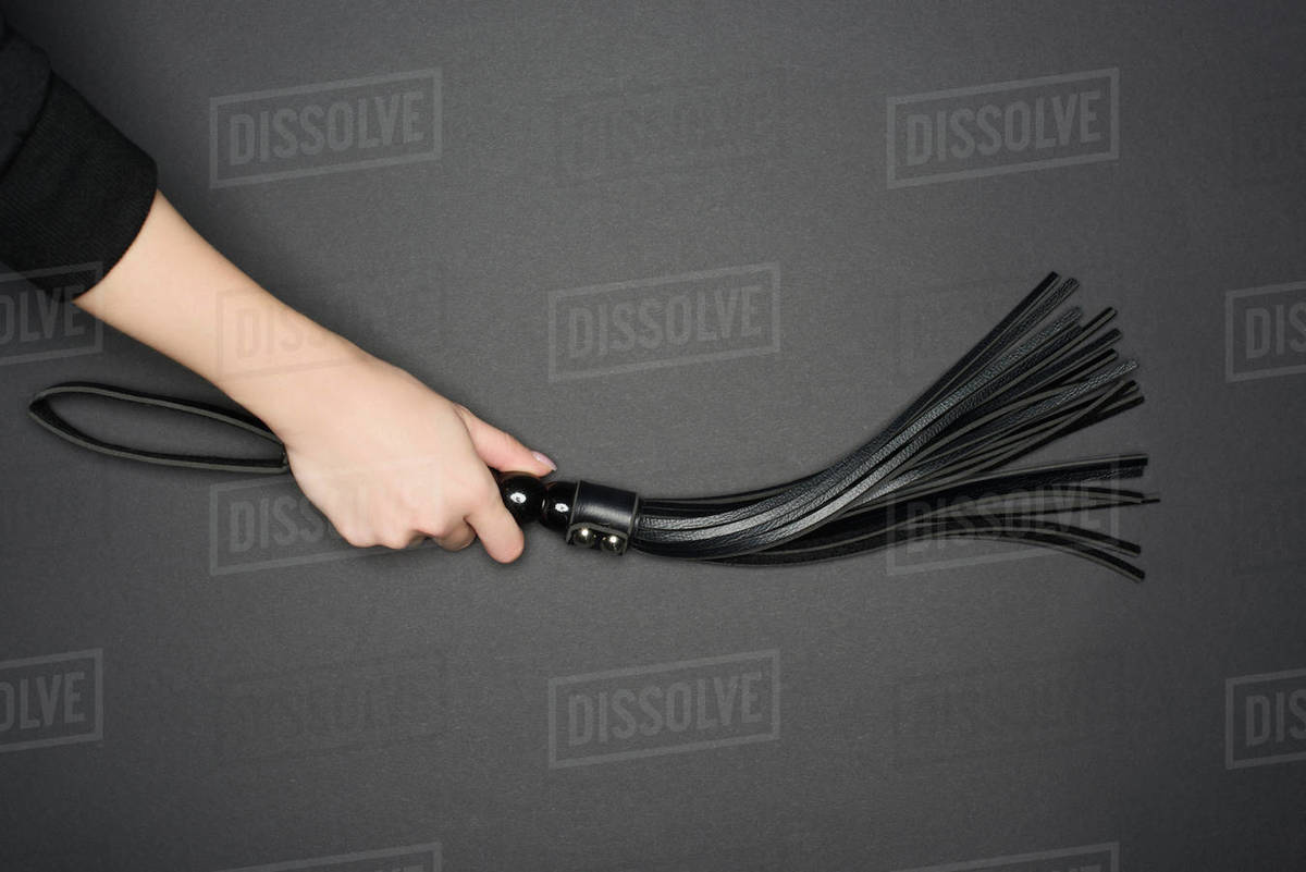 Cropped view of female hand holding leather flogging whip isolated on ...