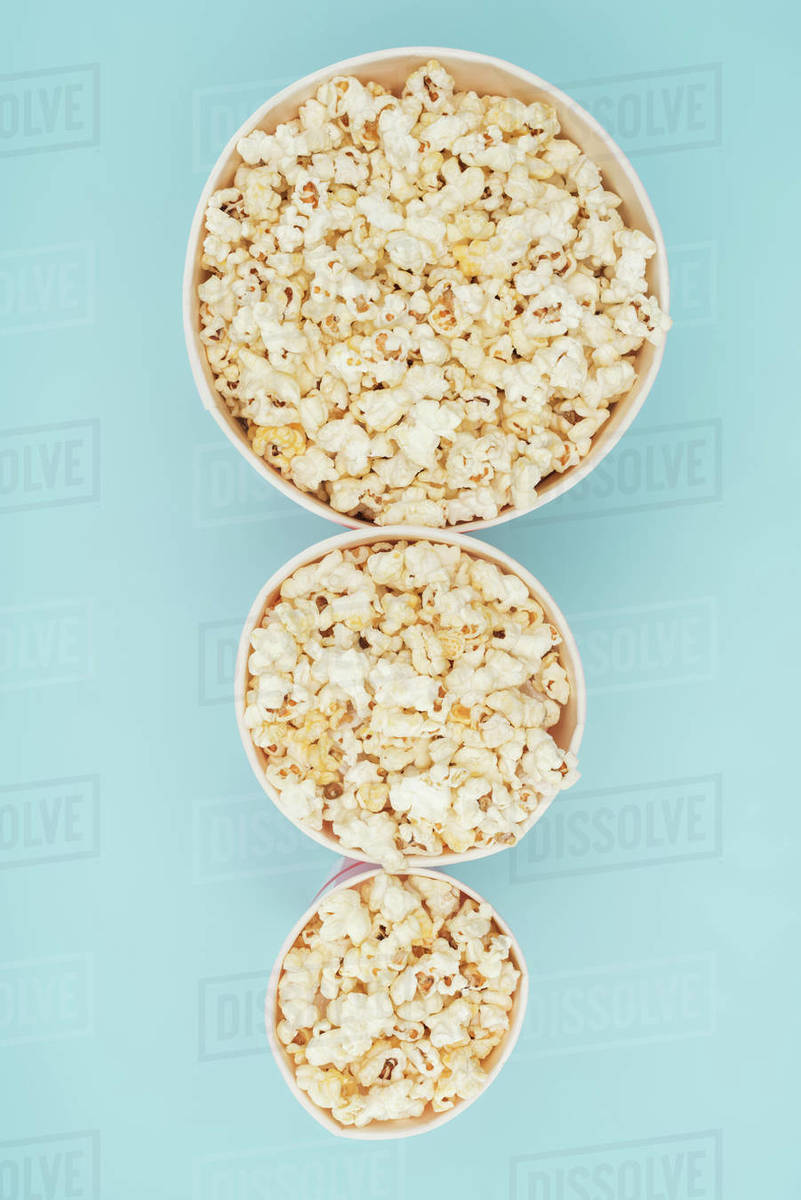 Top view of popcorn buckets of different sizes in vertical row isolated ...