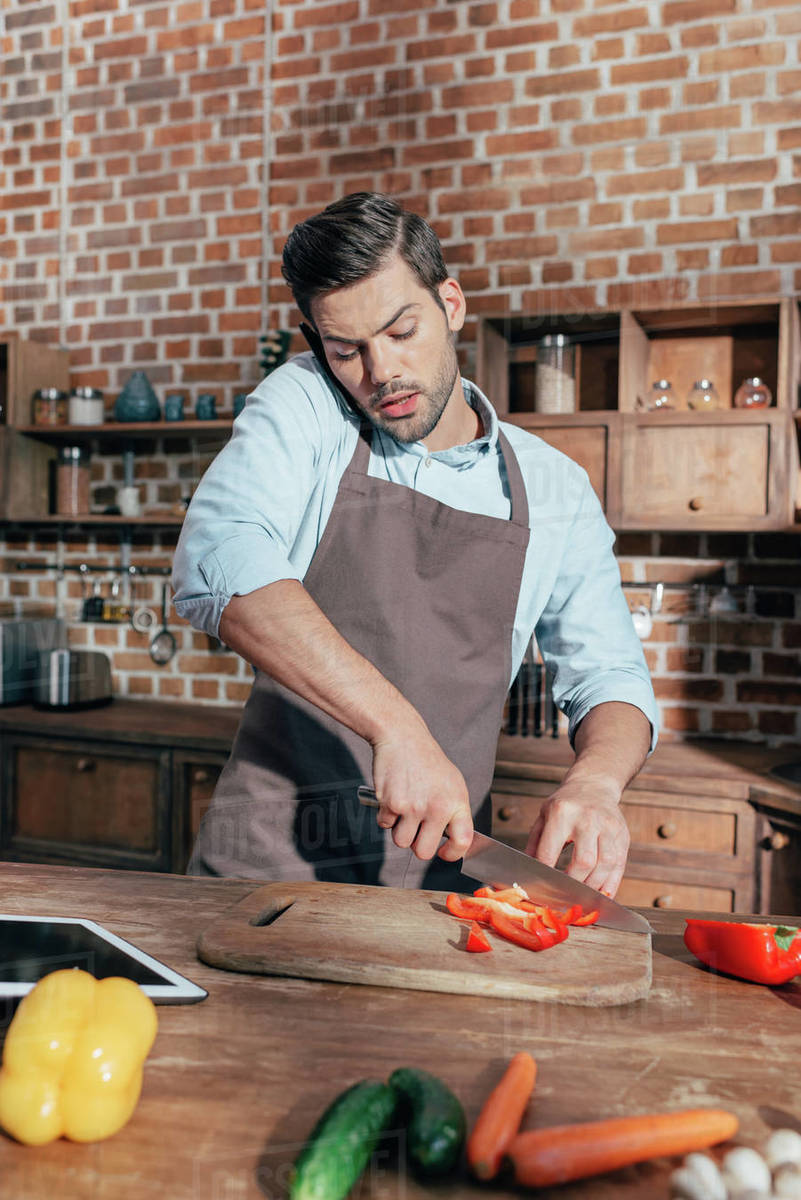 Handsome young man cooking and talking by phone - Royalty-free Stock ...