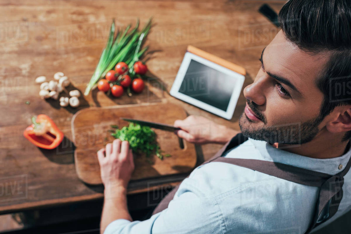 High angle view of handsome young man cooking with tablet - Stock Photo ...