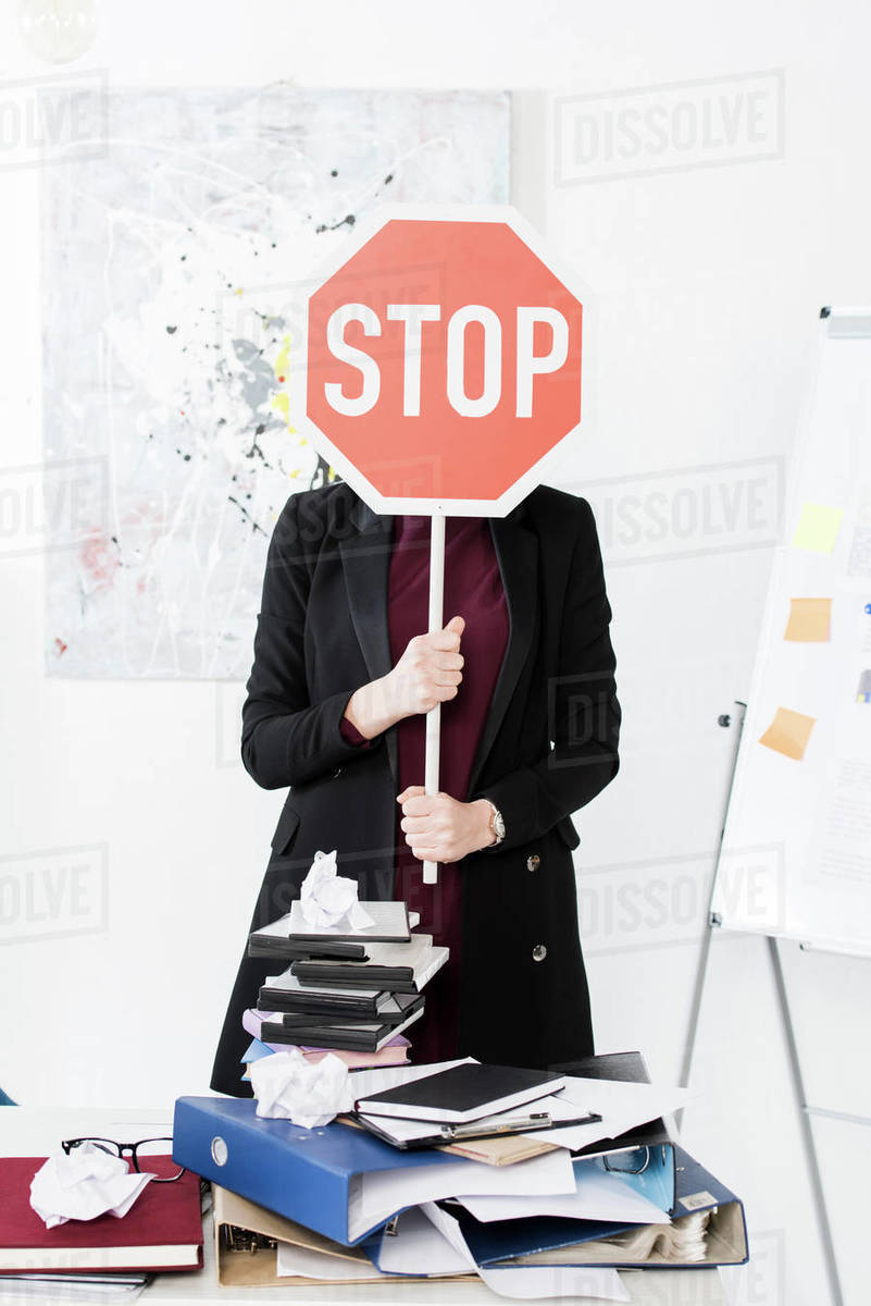 Businesswoman covering face with stop sign in office - Royalty-free ...