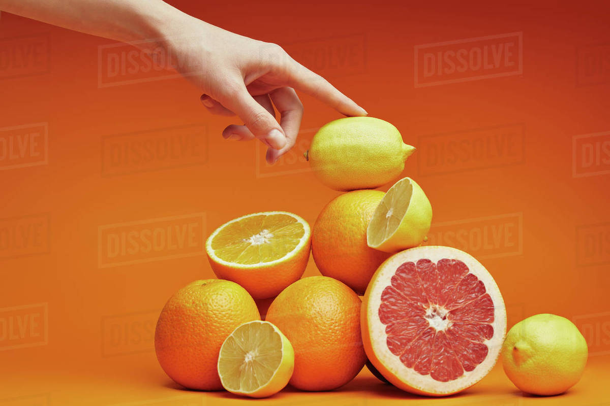 Cropped shot of person touching pile of fresh ripe citrus fruits on ...