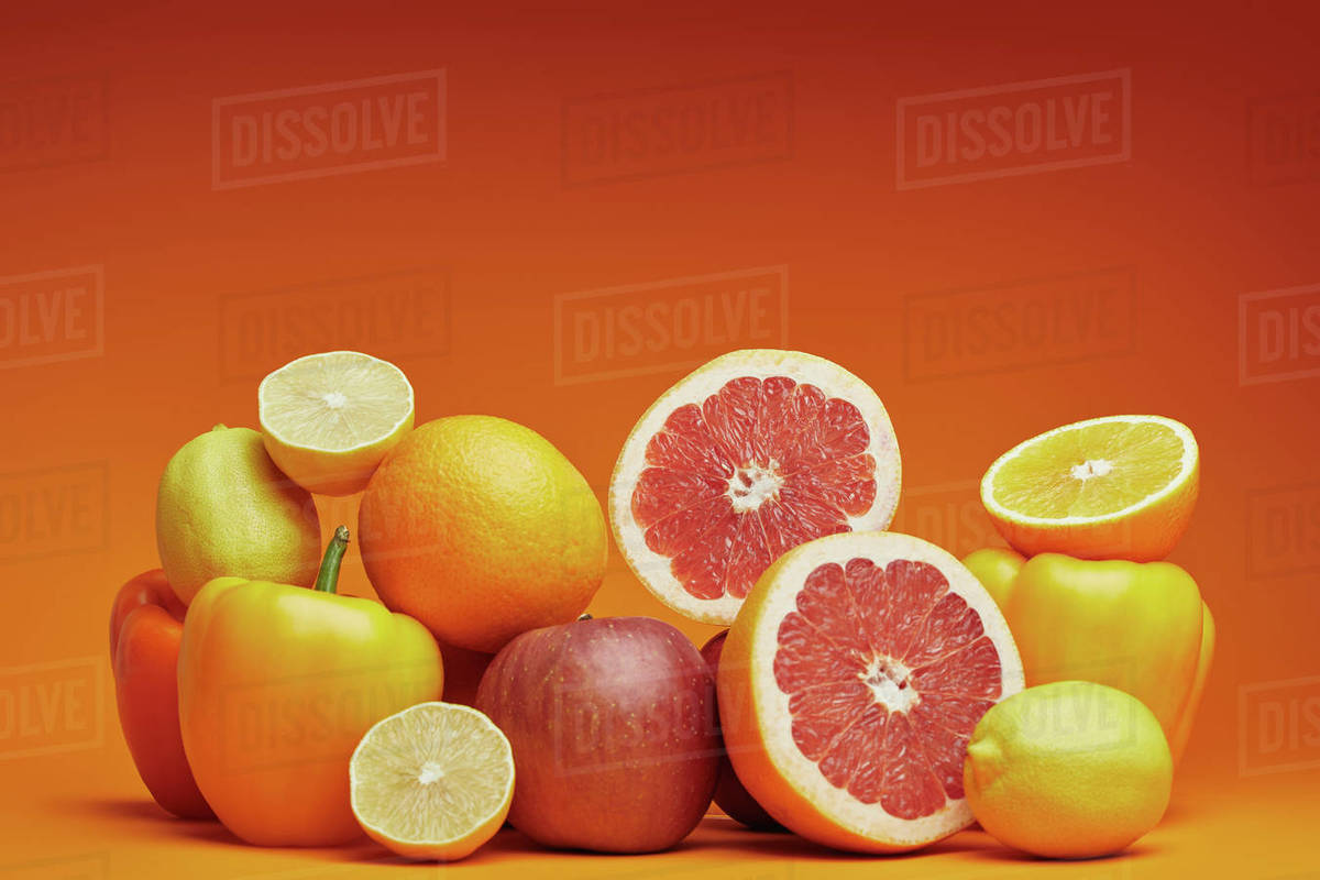 Close-up view of fresh ripe citrus fruits and bell peppers on orange ...