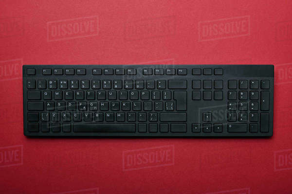 Top view of black plastic computer keyboard on red background - Stock ...