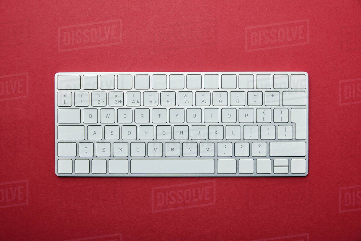 Top view of computer keyboard on red background - Stock Photo - Dissolve