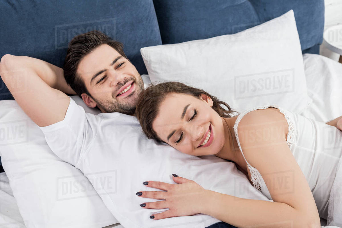 Beautiful smiling couple cuddling in bed at home - Royalty-free Stock ...