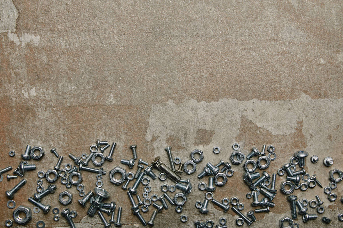 Top view of screws and bolts arranged on the background of old surface ...