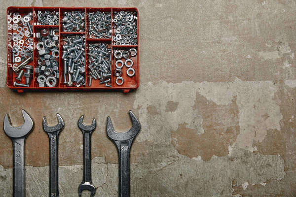 Flat lay with set of wrenches tools and box of screws on the background ...