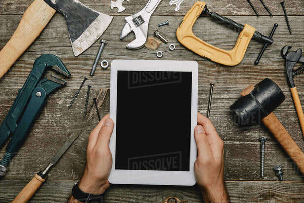 Partial view of man using digital table with blank screen on wooden ...