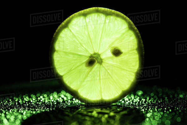 Slice of neon lime on black background with backlit - Royalty-free ...