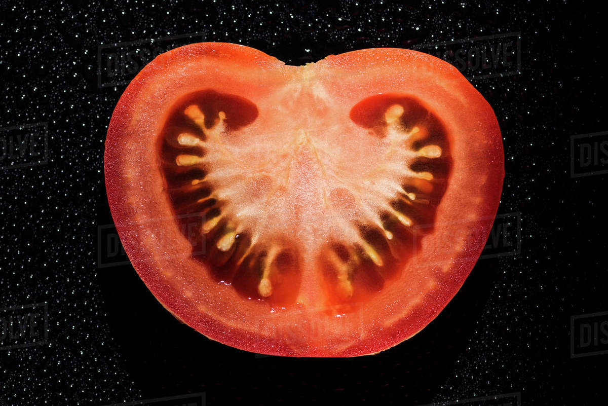 Slice of fresh tomato with water drops on black background - Stock ...