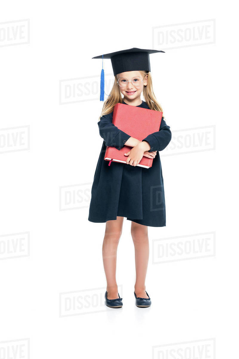 Happy schoolgirl in graduation hat with big book isolated on white ...
