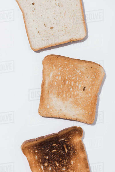 Top view of toasts in various roast stages on white surface - Royalty ...