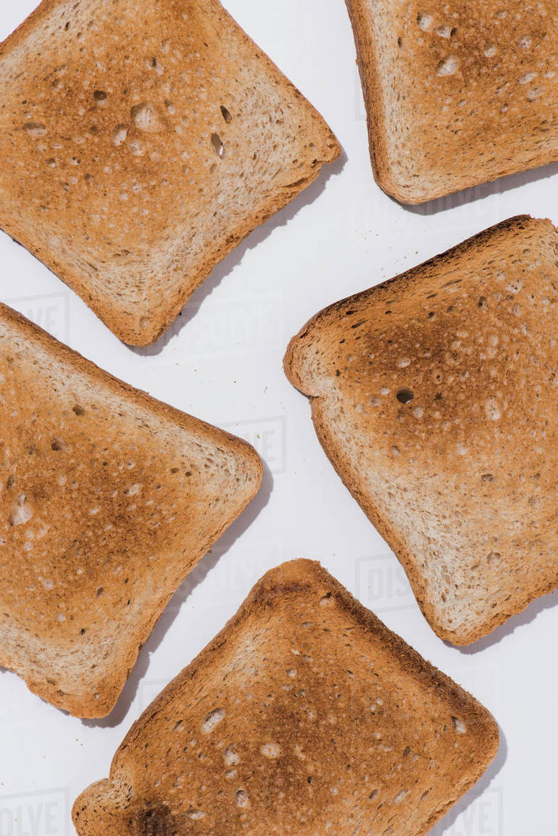 Top view of delicious crunchy toasts spilled on white surface - Royalty ...