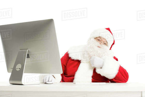 Santa Claus working on computer and looking at camera with thoughtful ...