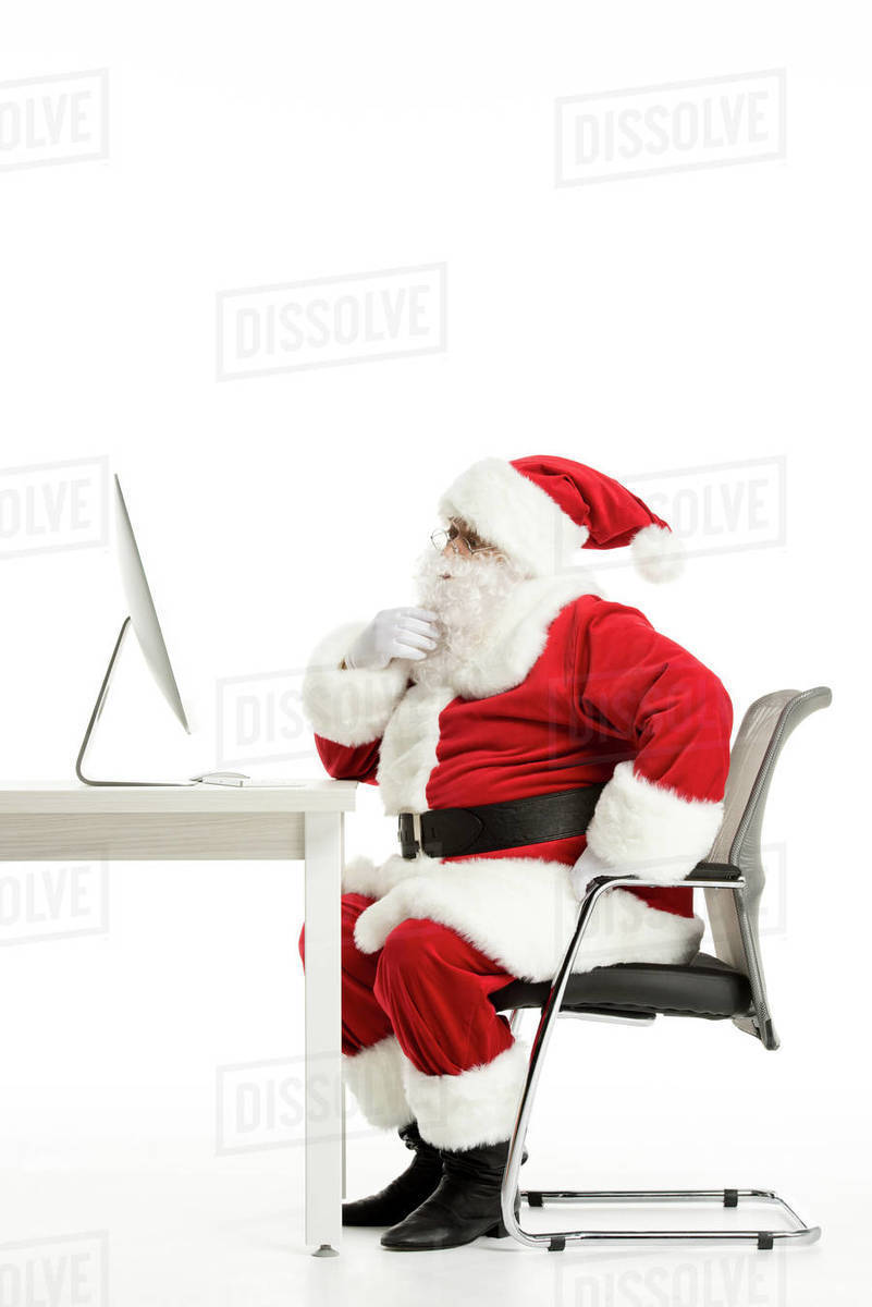 Side view of thoughtful Santa Claus looking at computer isolated on ...