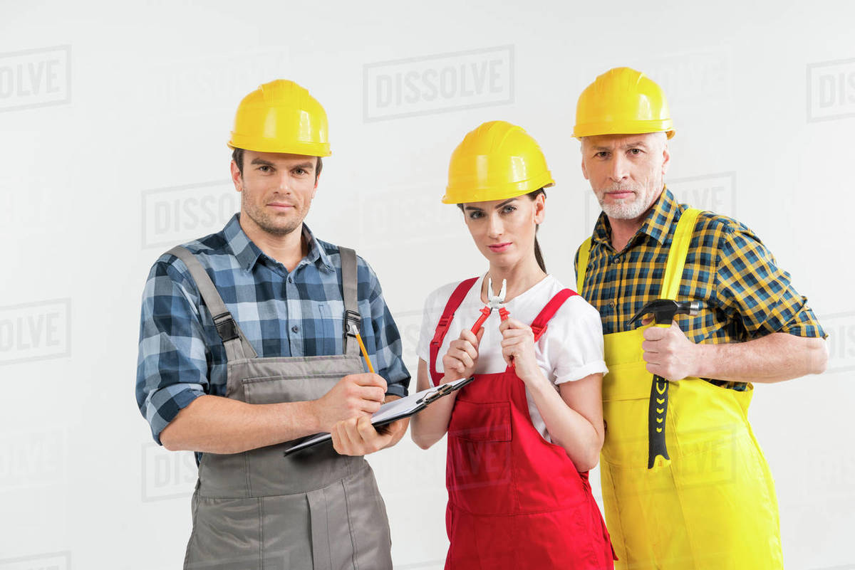 Group of professional male and female construction workers looking at ...