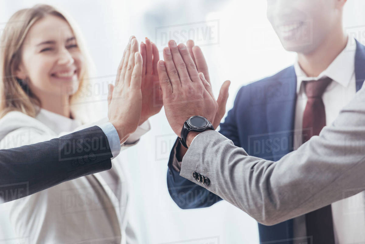 cropped shot of professional successful business team giving high five ...