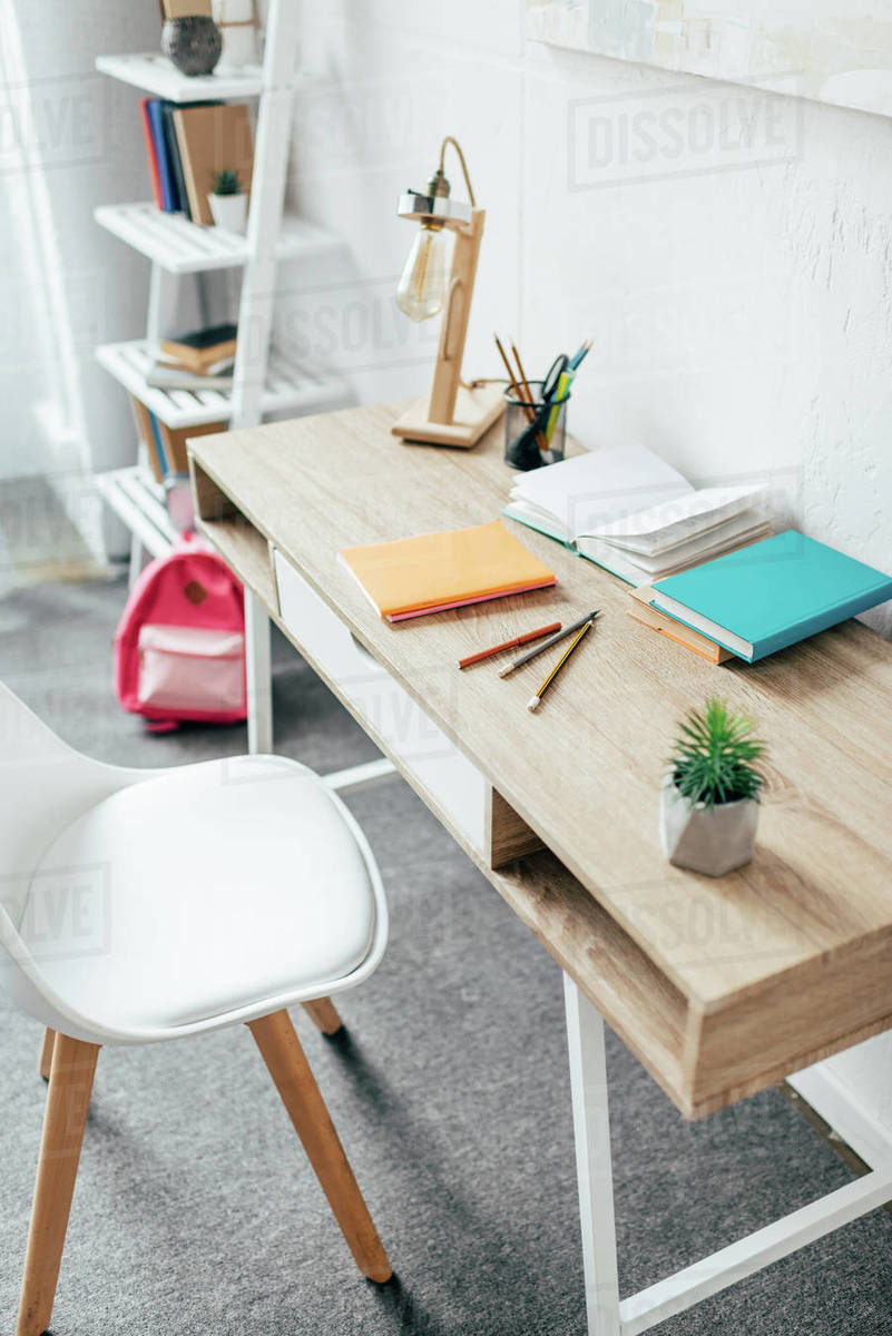 Minimalistic room interior with writing desk and school supplies placed ...