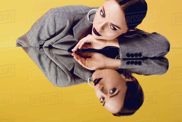 Beautiful glamorous woman in formal wear looking at mirror reflection ...