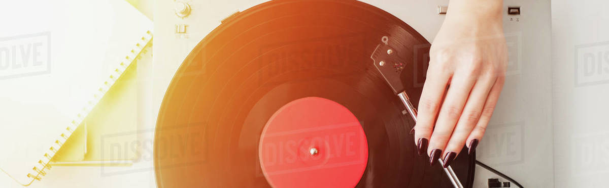 Cropped view of woman playing vinyl record on vintage player - Royalty ...
