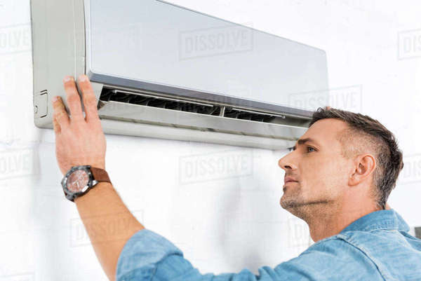 Handsome adult man looking into air conditioner - Royalty-free Stock ...