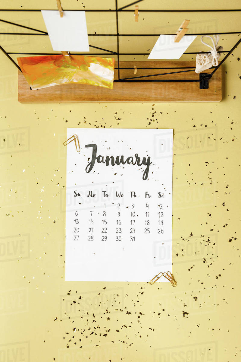 Top view of January calendar with golden confetti and cards with ...