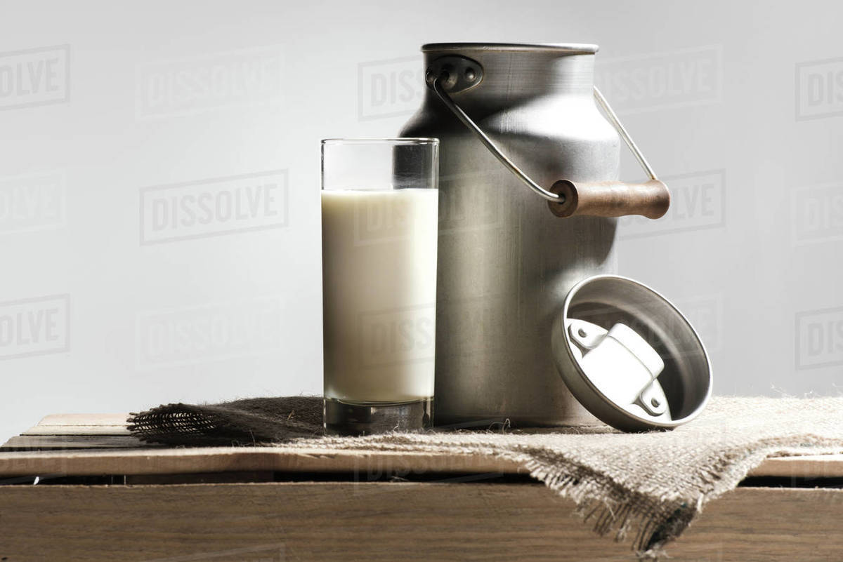Close-up view of fresh milk in glass and can on grey - Royalty-free ...