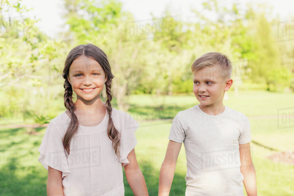 portrait of smiling siblings in casual clothing in park - Royalty-free ...