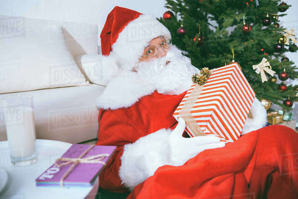 portrait of santa claus with gift in hands looking at camera - Royalty ...