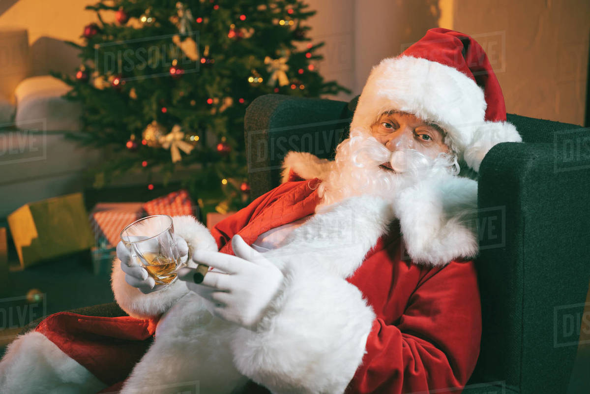 portrait of santa claus with glass of whiskey and cigar in hands ...