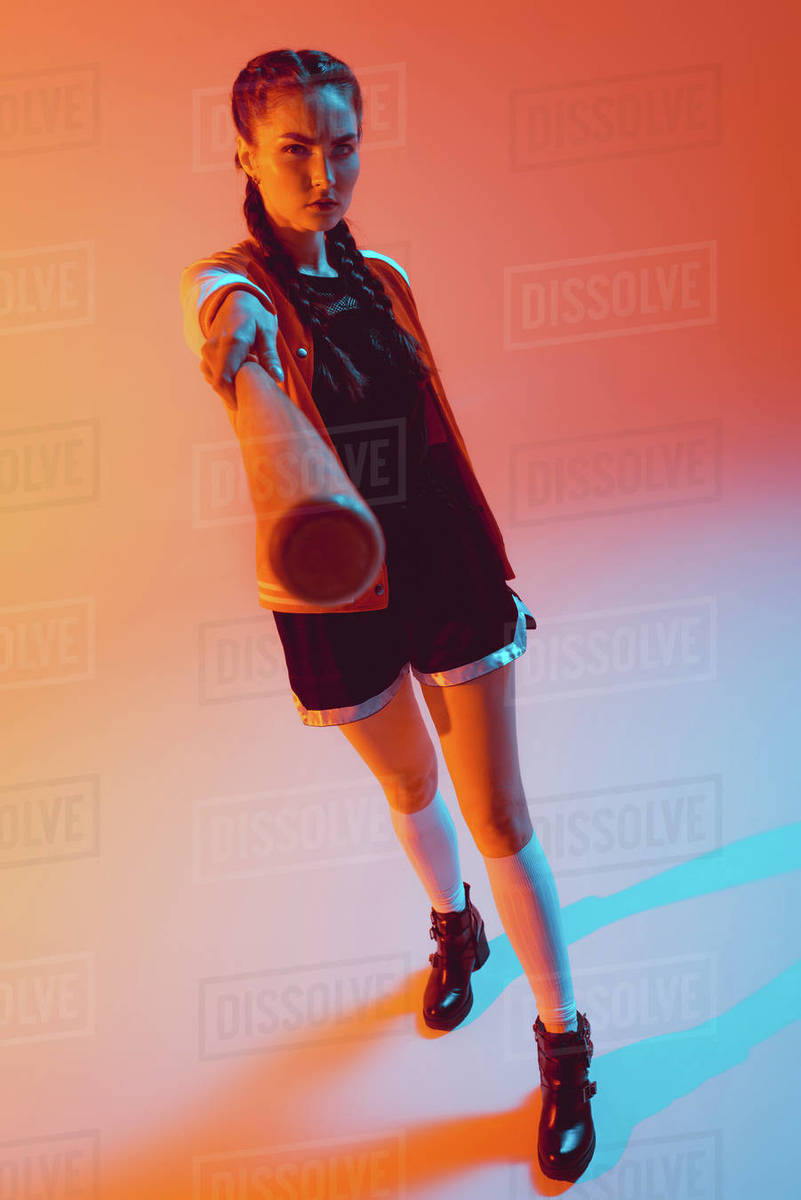 toned picture of stylish woman pointing at camera with baseball bat ...