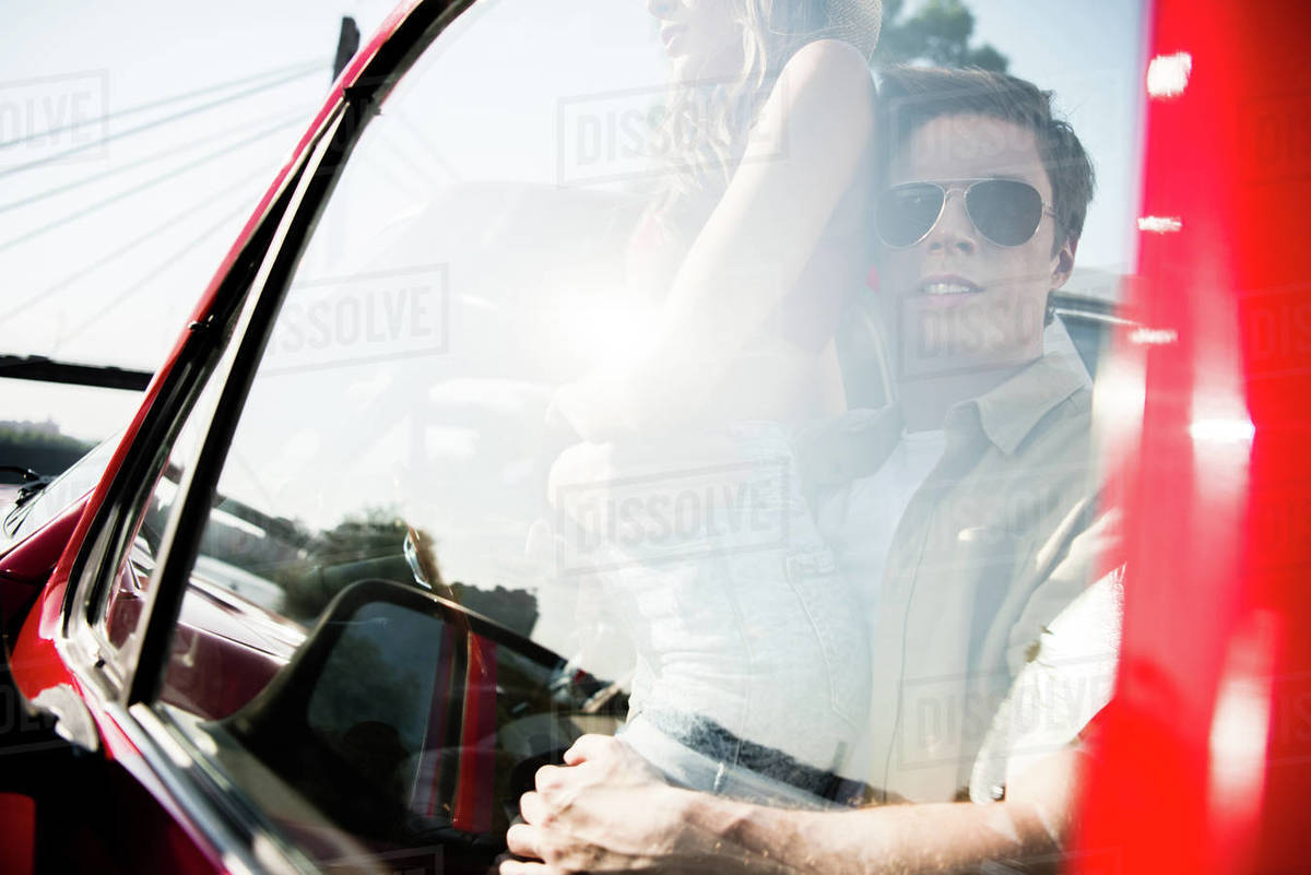Beautiful young couple behind car window - Stock Photo - Dissolve