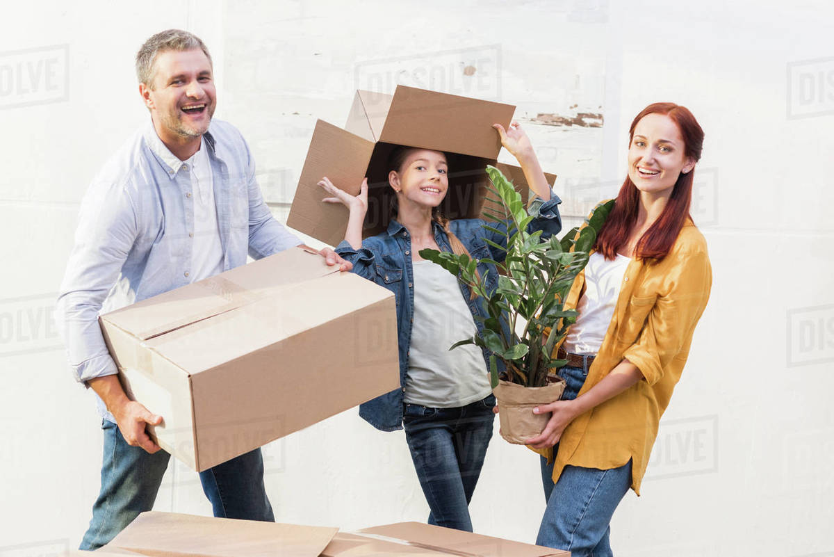 Portrait of cheerful family looking at camera at new home - Stock Photo ...