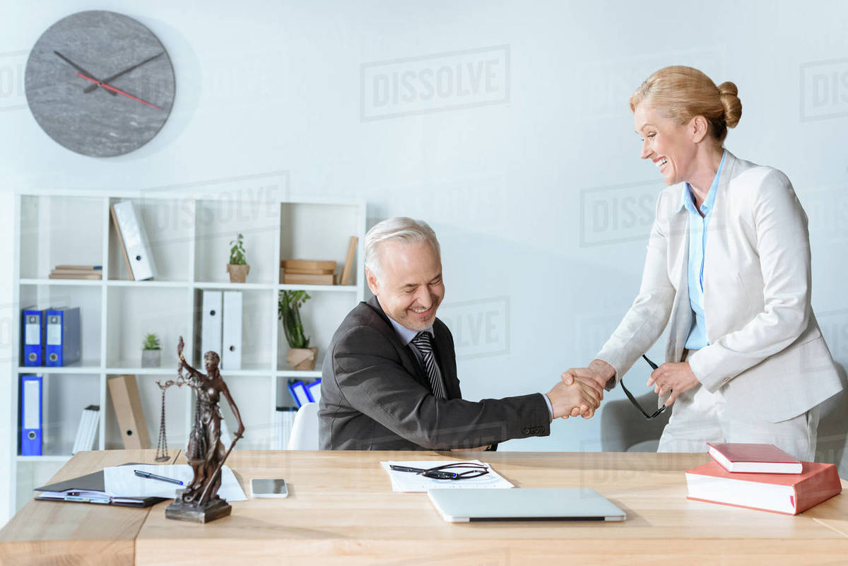 happy mature lawyers shaking hands at workplace - Royalty-free Stock ...