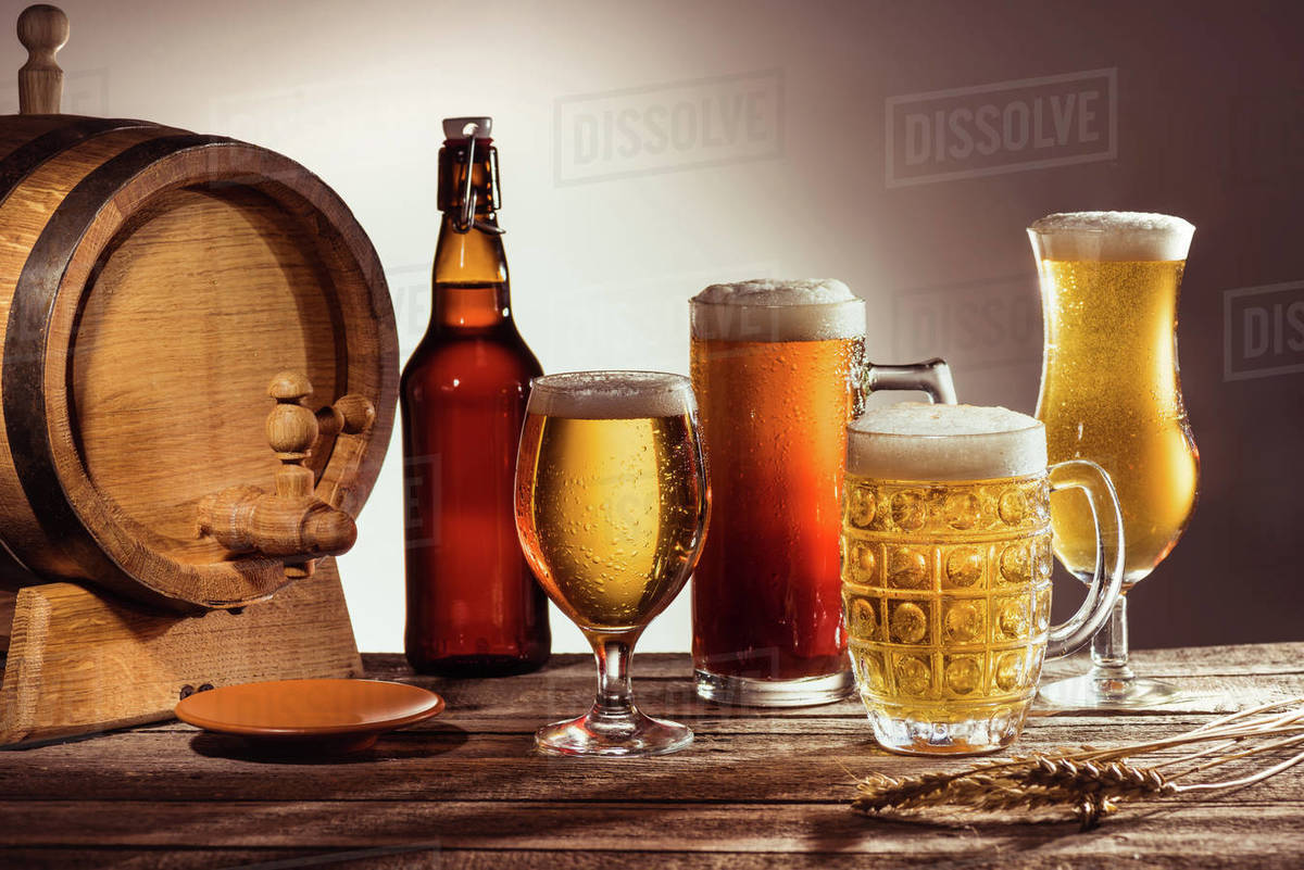 barrel and different beer in glasses and bottle on wooden tabletop with ...