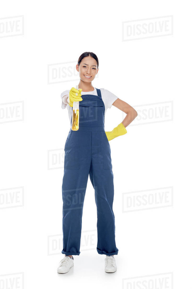 cheerful asian cleaner with detergent in hand standing akimbo isolated ...