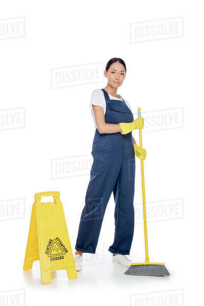 asian cleaner in uniform with broom in hands looking at camera isolated ...