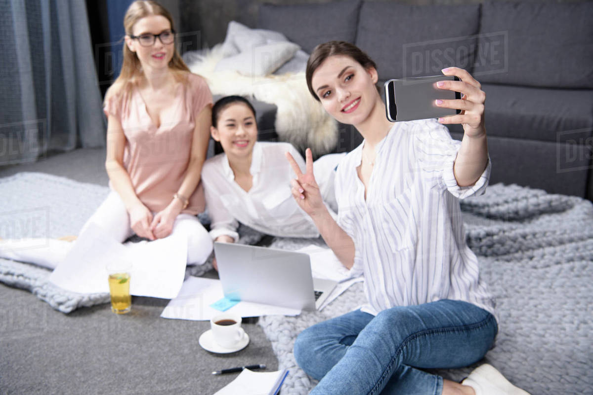 Smiling colleagues taking selfie while working on business project ...