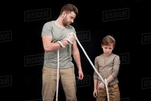 Father with rope tied upset little son, family problems concept ...