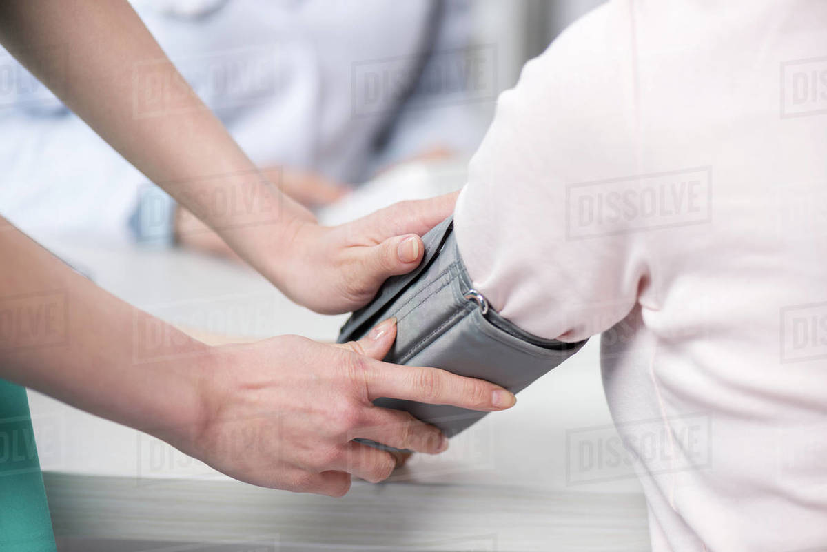 Cropped shot of nurse putting blood pressure cuff to patient - Royalty ...