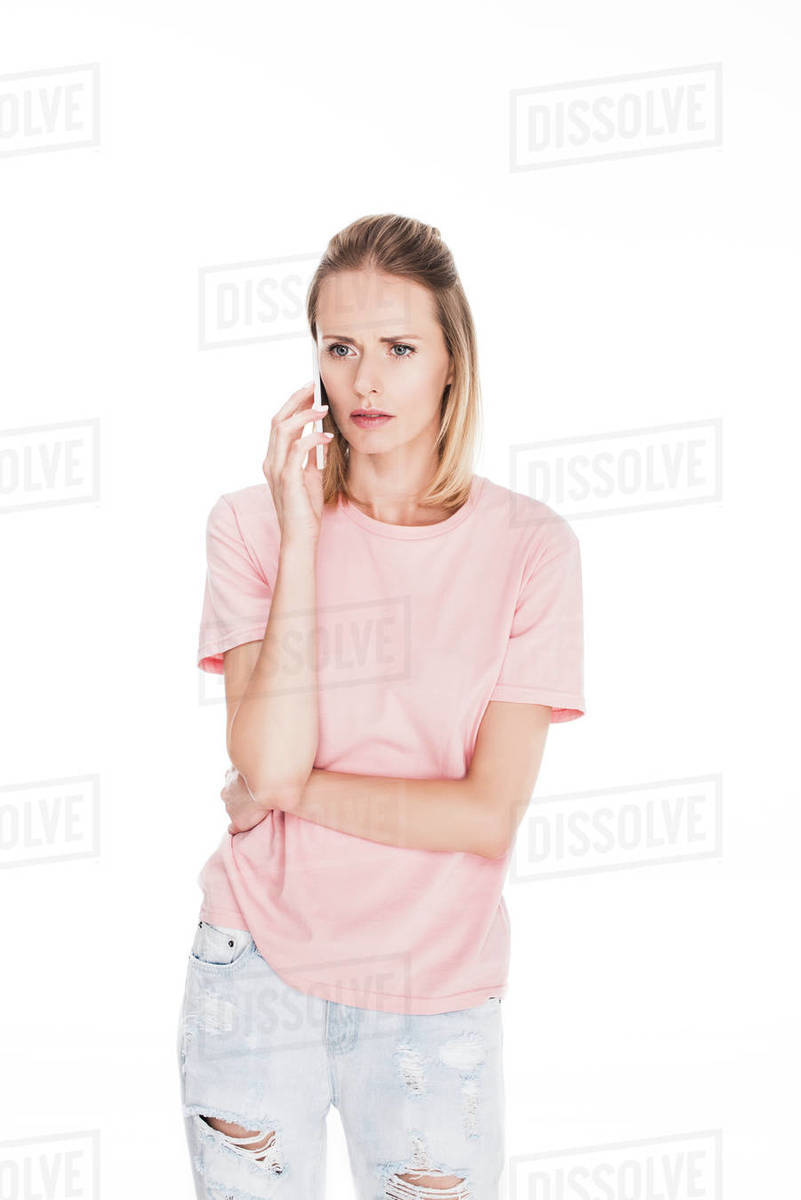 Concerned woman in pink t-shirt talking on phone, isolated on white ...