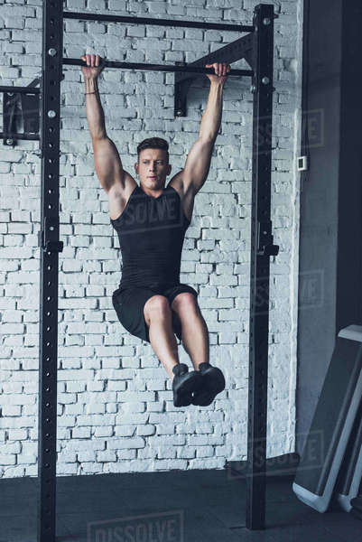 Young man in sportswear doing pull ups on pull up bar in gym - Stock ...