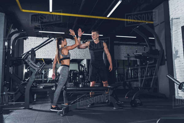 Sportive couple giving high five to each other in gym - Stock Photo ...