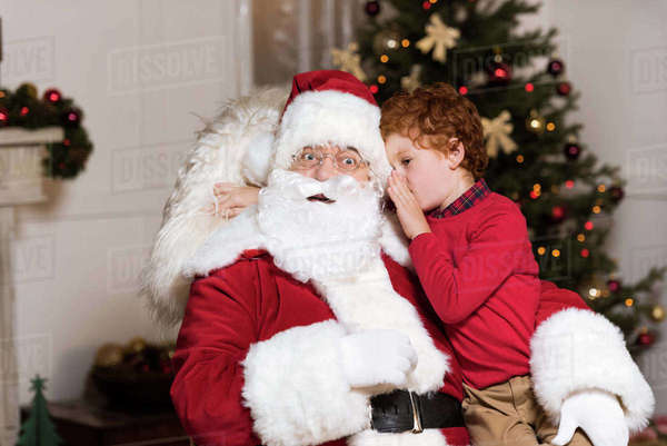 Portrait of little boy telling secret to shocked Santa Claus - Stock ...