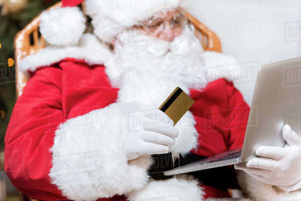 Santa Claus with credit card and laptop shopping online at home ...